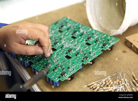 A Man Collects A Printed Circuit Board The Worker Solders The Radio Components And Assembles