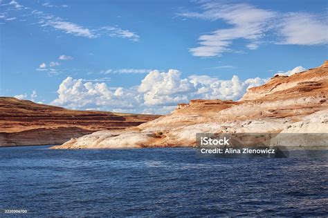 Layered White Sandstone Cliffs Over Deep Blue Water At Lake Powell