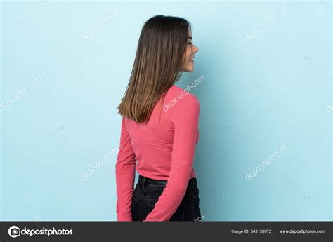 Teenager Girl Isolated Blue Background Back Position Looking Back