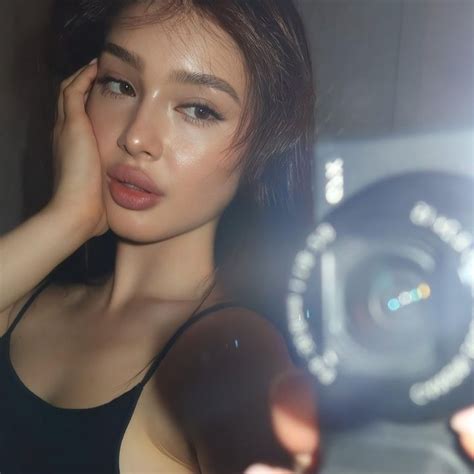 A Woman Holding A Camera In Front Of Her Face