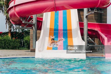 물 아쿠아 공원에서 화창한 날에 워터 슬라이드를 타고 내려간 후 수영장에서 미끄러지면서 웃고 있는 어린 소년 더운 날씨 활동적인 휴가 건강한 라이프스타일에 상쾌한 아이