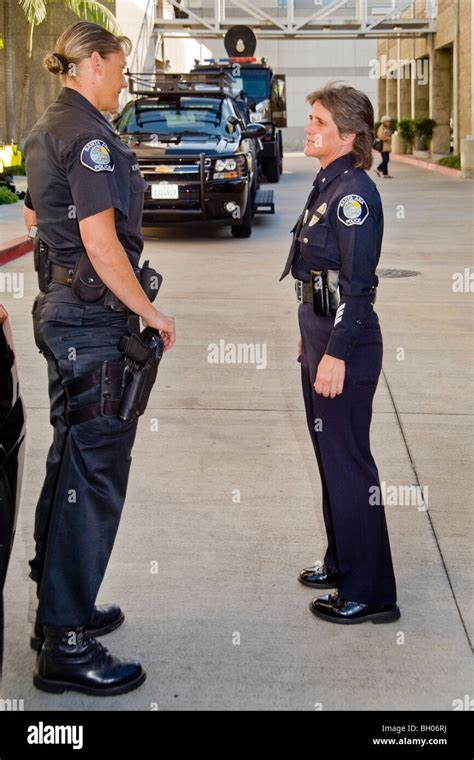 A Short Female Police Commander Speaks With A Tall Woman Officer At The