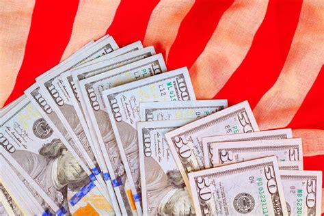 Stacks Of Cash Arranged Artistically On A Vibrant Red And White Striped