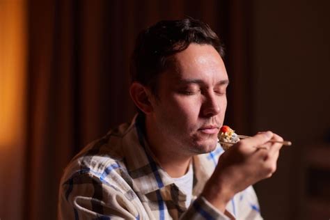 Ein Junger Mann Isst Sushi Aus Der Hauslieferung Und Zeigt Mit Dem