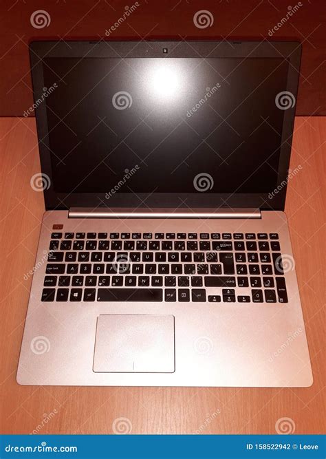 Laptop Turned Off With Light Reflection On Display Open And Laid On Wooden Desk Editorial