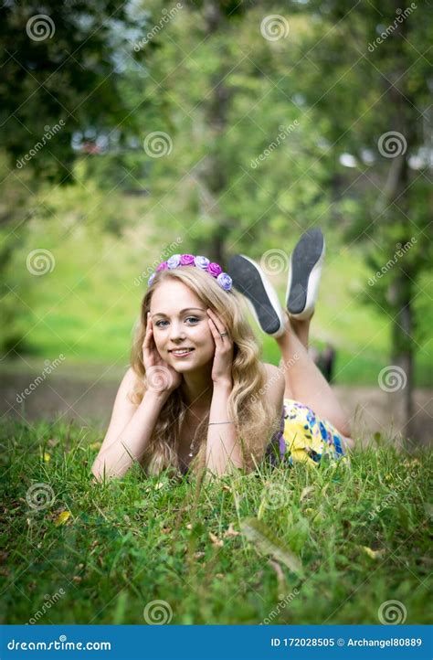 Beautiful Blonde Girl Lying In The Grass And Smiling Stock Image