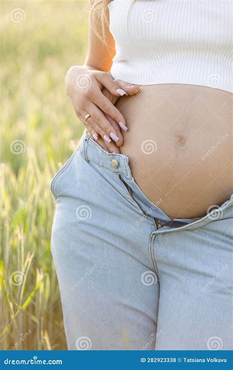 Unrecognizable European Pregnant Woman With Naked Belly Stands In