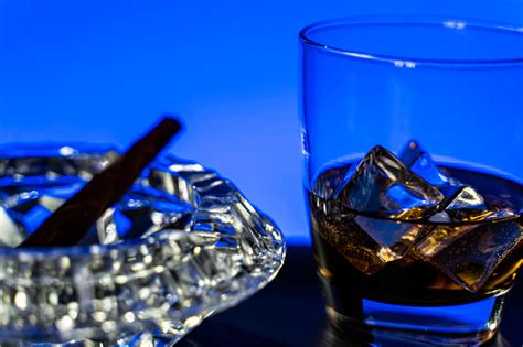 얼음 조각과 시가가 있는 위스키 유리가 파란색 배경에 크리스탈 재떨이에 새겨서 클로즈업 0명에 대한 스톡 사진 및 기타 이미지 0명 각얼음 결정체 Istock