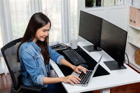 smiling asian it typing online software development on laptop