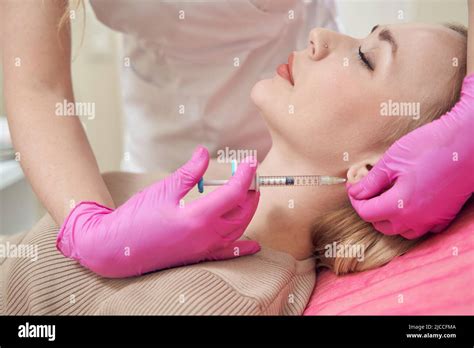 Pretty Caucasian Female With Silk Skin Receiving Injection Into Her Ear