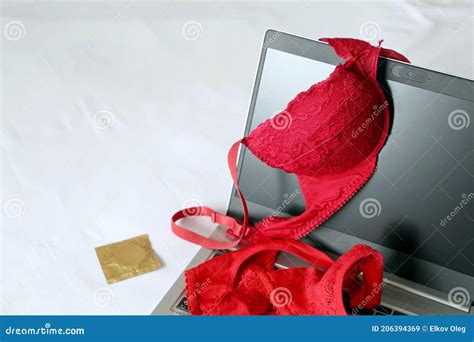 Female Lace Panties Red Bra And Condom On Laptop On A Bed Stock Image