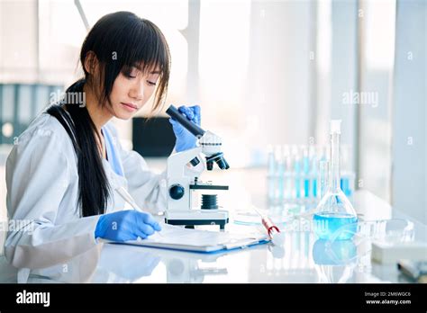 Beautiful Female Scientist Analyzing Microscope Slides Working In