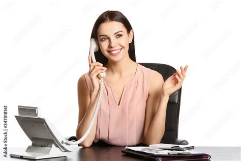 Beautiful Young Secretary Talking By Telephone At Table On White