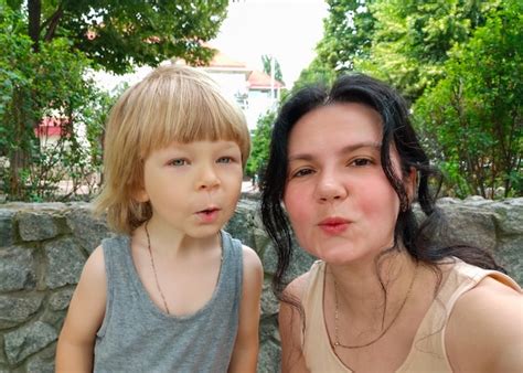 Premium Photo Mom And Son Smiling While Looking At Camera Mother