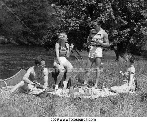 1930s Two Couples Having Summer Picnic With Food And Drink Spread Out On Blanket The Tip Of A