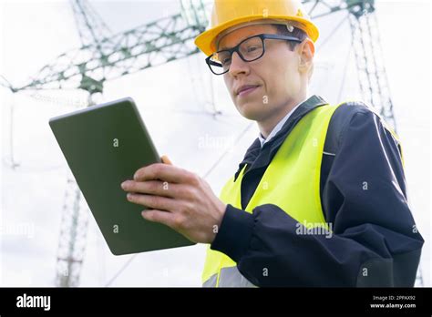 Engineer With Digital Tablet On A Background Of Power Line Tower High