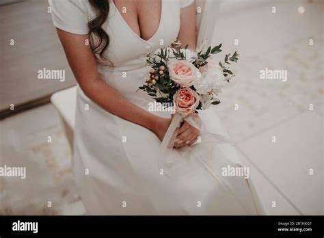 Stylish Bride Without A Face In A Modest Simple White Dress Holds An