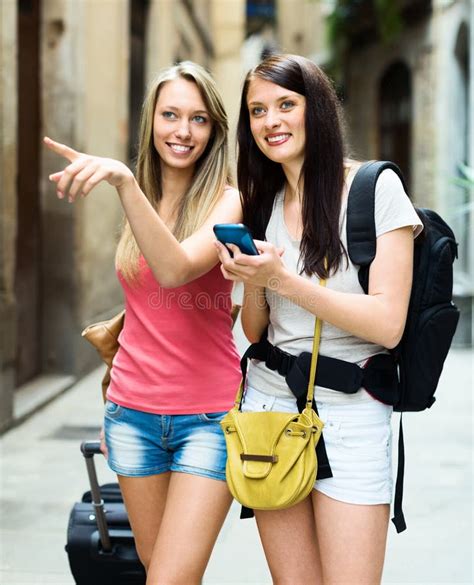 Duas Meninas De Sorriso Que Usam O Smartphone Para Encontram Uma