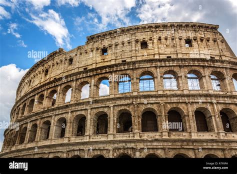 the colosseum in a partial cloudy day seen from a steep angle from