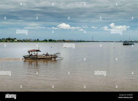 Small Ferry Crossing The Mekong River In Cambodia Under Stormy Skies