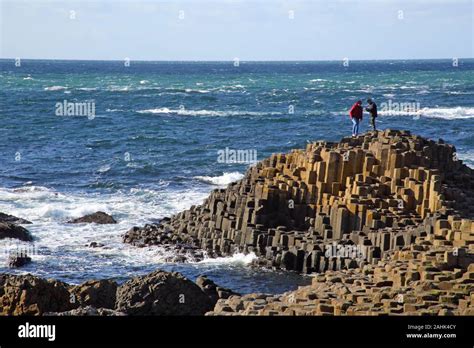 Massive Basalt Columns Of The Giants Causeway With Two Men Standing On
