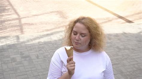 A Plump Caucasian Woman Eats An Ice Cream Cone While Walking Stock Footage Video Of Woman