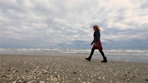 Photoshoot Of A Young Girl Walking On The Beach On A Cloudy Day Looking