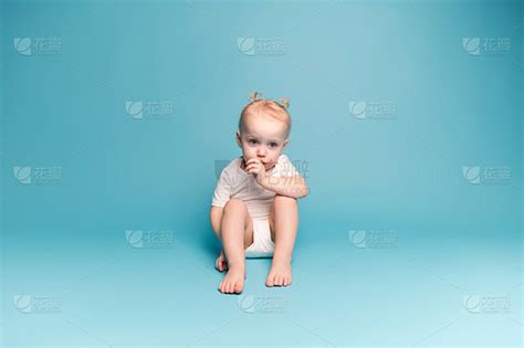 小女孩低头吮吸手指