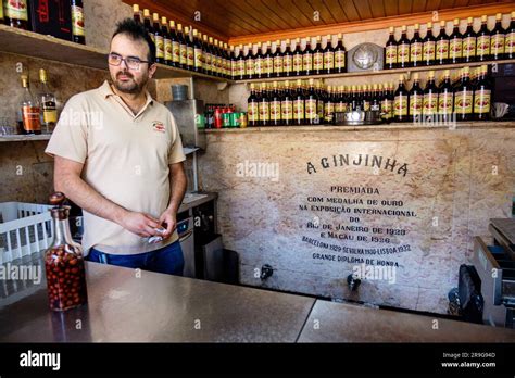 Ginjinha Sour Cherry Liqueur Bottles On Shelf Worker Inside A Ginginha Bar Largo De São