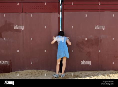 Girl At The Beach Peeping The Hidden Sea Trough A Slit In Steel Wall Stock Photo Alamy