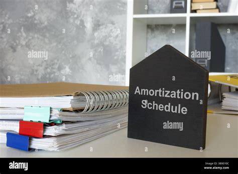 Amortization Schedule And Stack Of Documents Debt Repayment Planning