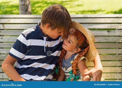 Fratello E Sorella Che Giocano Insieme Seduta Sul Banco Allaperto