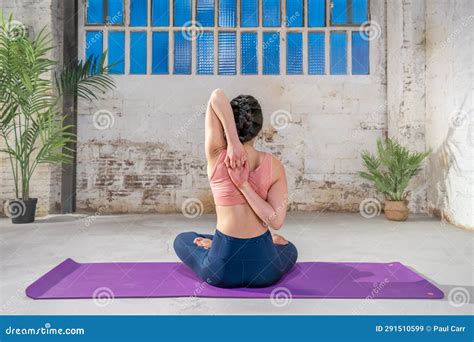 Young Woman Practicing Yoga Sitting In A Industrial Gym Pose Working