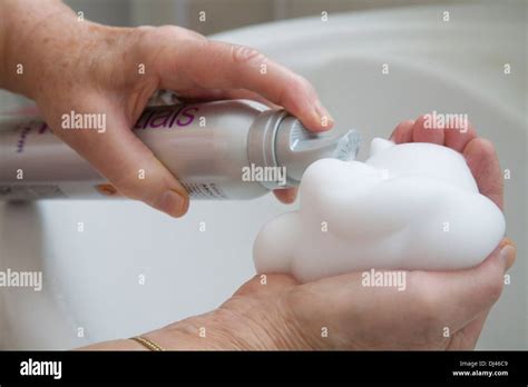 Close Up Elderly Woman Squirting Hair Mousse Into Hand Before Applying