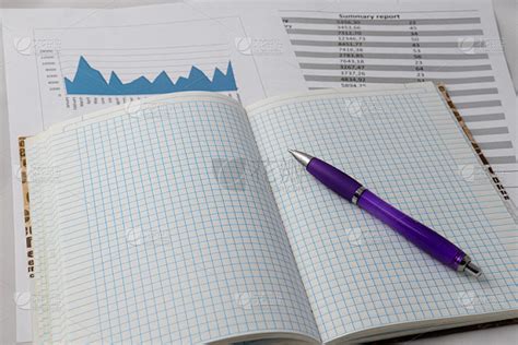 笔记本，纸和桌子，笔在桌子上