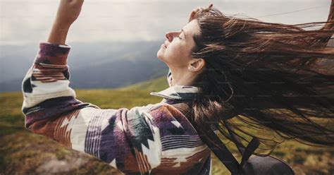 산 꼭대기에 배낭과 바람이 부는 머리를 가진 세련된 힙스터 소녀 편안한 행복한 젊은 여성의 초상화 평온한 분위기 놀라운 분위기의 순간 사진 Unsplash의 여자 이미지