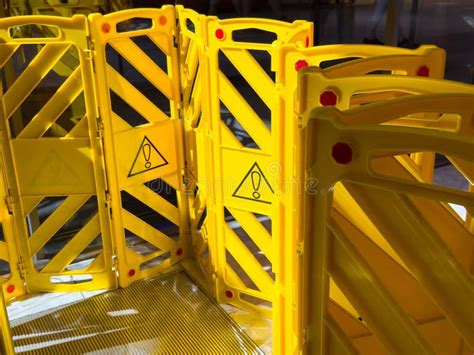 Yellow Caution Barrier With Warning Symbols In Public Area Stock Image