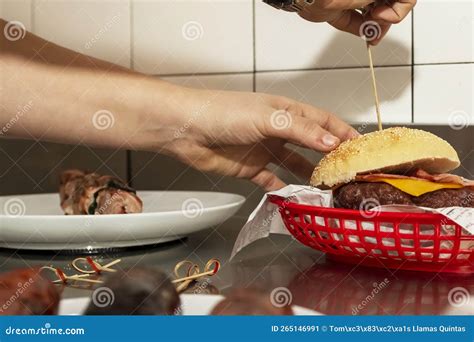 The Hands Of A Chef Assembling A Beef Burger Cooking On Charcoal Grill