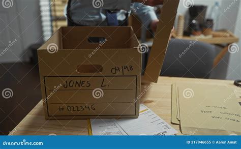 A Man In A Detective S Office Handles Evidence And Paperwork