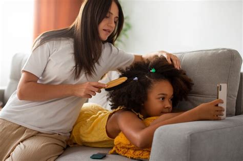 Mamá Ayudando A Su Hijo A Peinar El Cabello Afro Foto Gratis