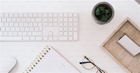 A Desk With A Keyboard Mouse Glasses And A Notepad Photo Desktop Image On Unsplash