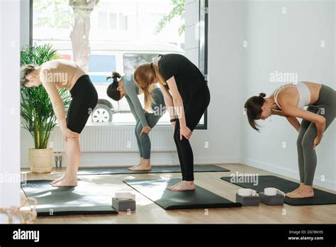 Groupe De Femmes Pratiquant Le Yoga à Côté Dun Instructeur Se Pencher