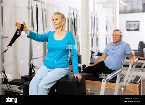 Active Old Woman Stretching Upper Body Practicing Pilates Exercise In
