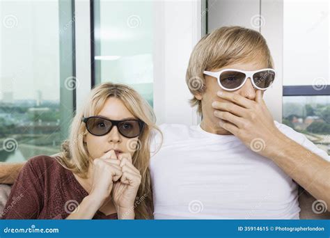 Couple Wearing 3d Glasses And Watching Tv With Concentration At Home