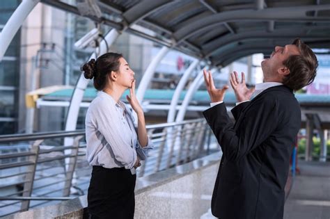 Premium Photo Business Colleagues Arguing While Standing On Bridge