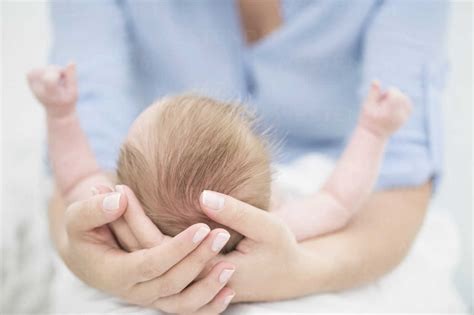 Mother Cradling Baby In Arms Stock Photo