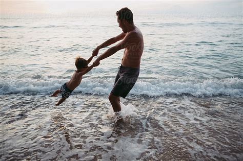 Young Dad And Son Enjoying Tropical Bali Beach Together At Sunse By Stocksy Contributor Rob