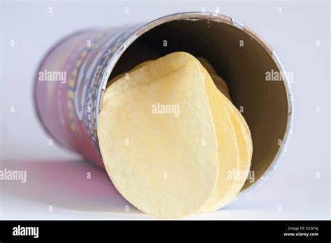 Open Tub Of Pringles Original With Contents Spilled On White Background