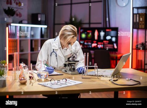 Young Female Researcher Looking At The Microscope In The Life Science