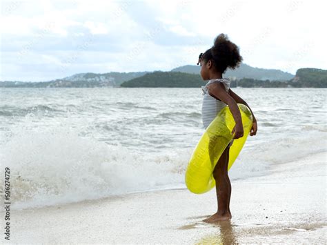 Little African Girl Wearing Stripy Swiming Suit Holding Neon